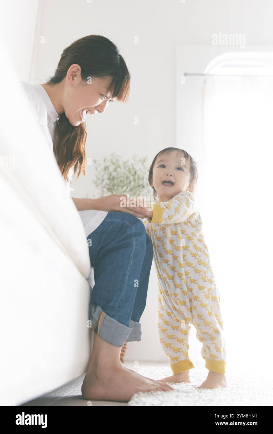 Baby cuddling with mother Stock Photo - Alamy