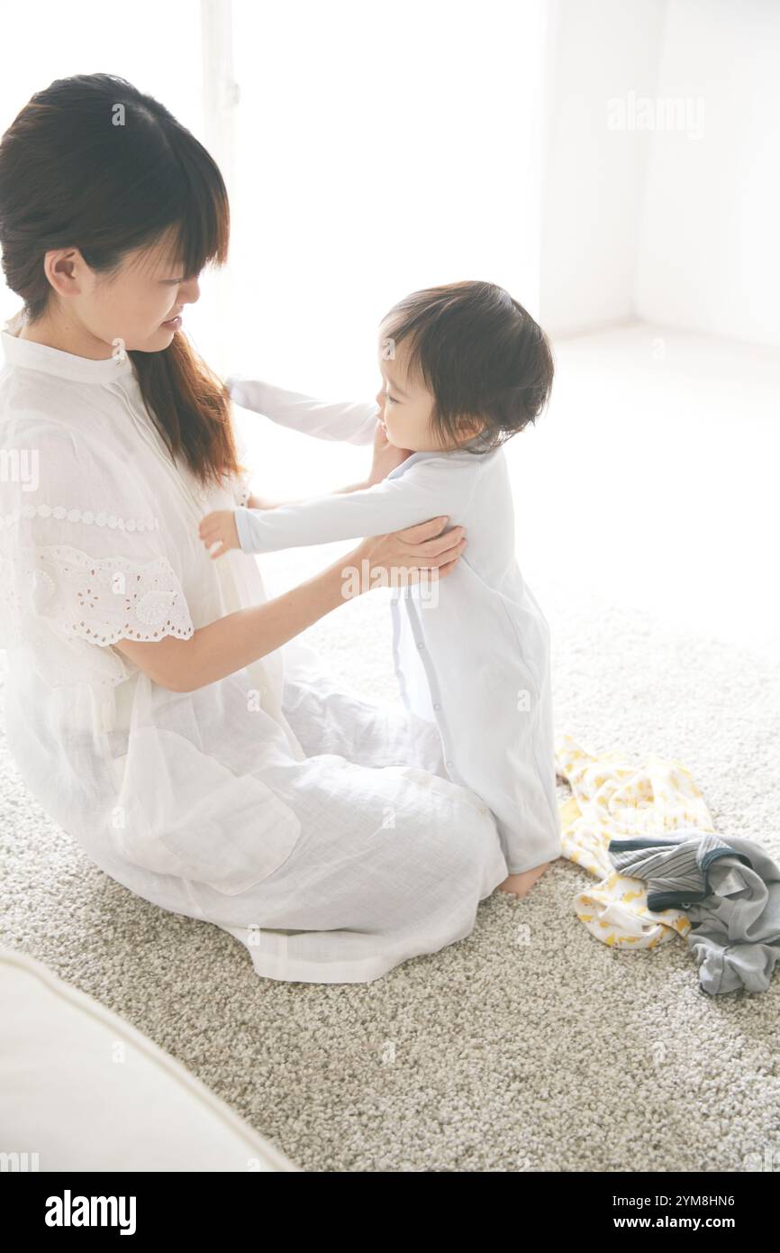 Baby getting dressed Stock Photo - Alamy