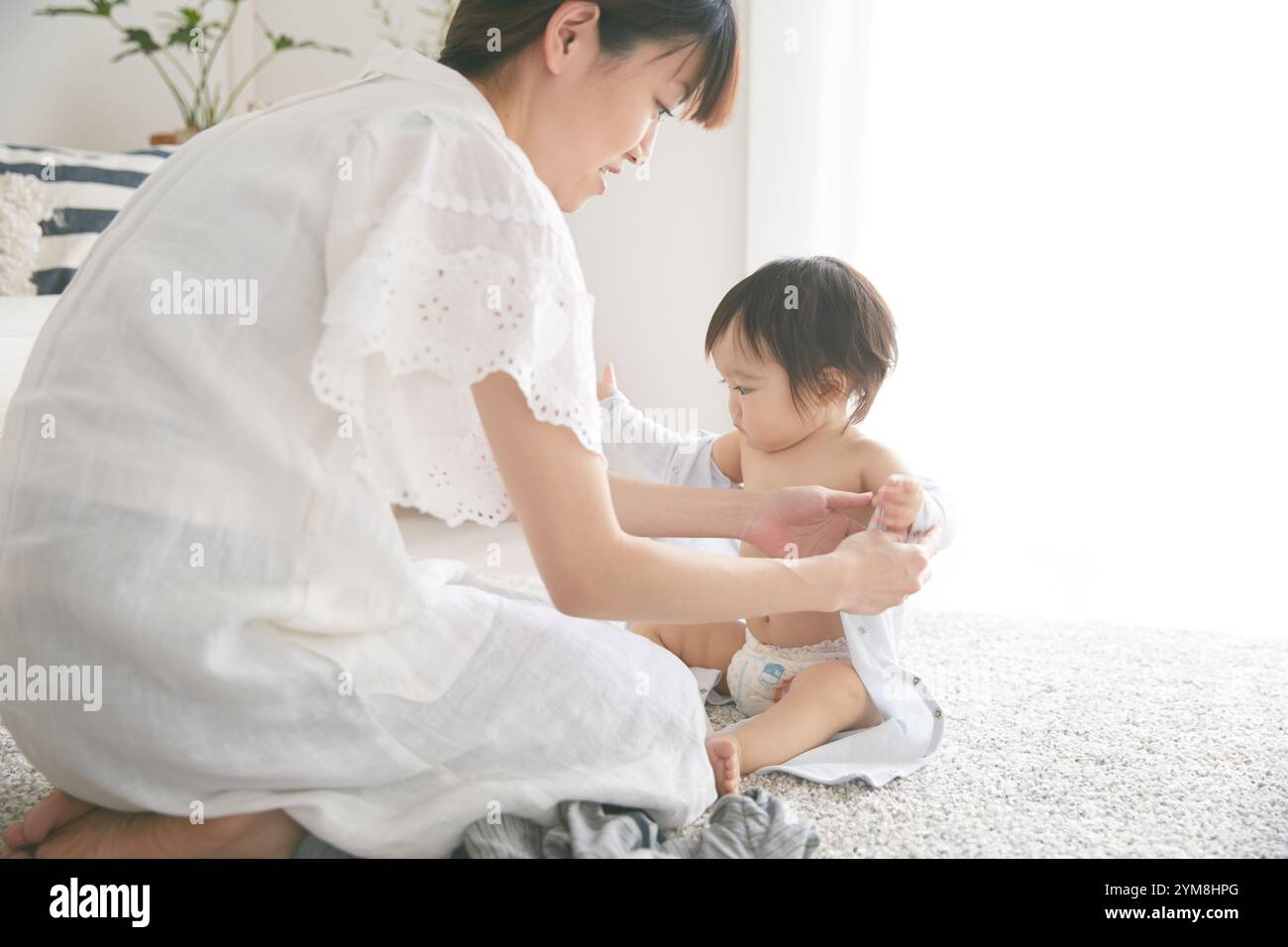 Baby getting dressed Stock Photo - Alamy