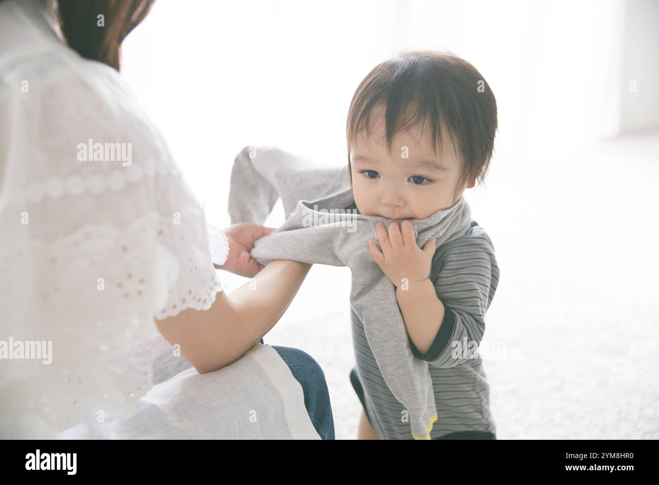Baby getting dressed Stock Photo - Alamy