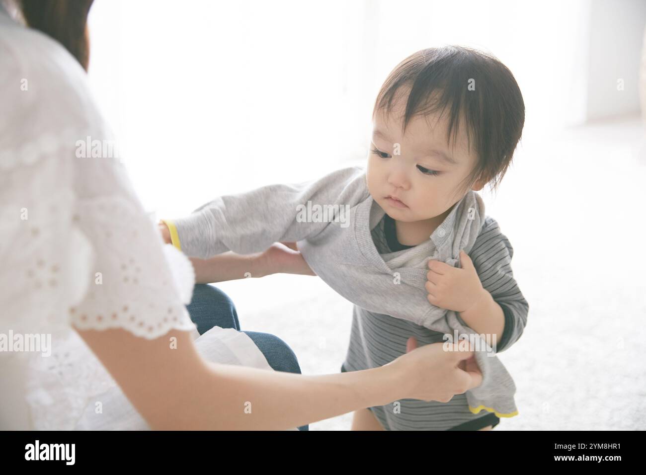 Baby getting dressed Stock Photo - Alamy