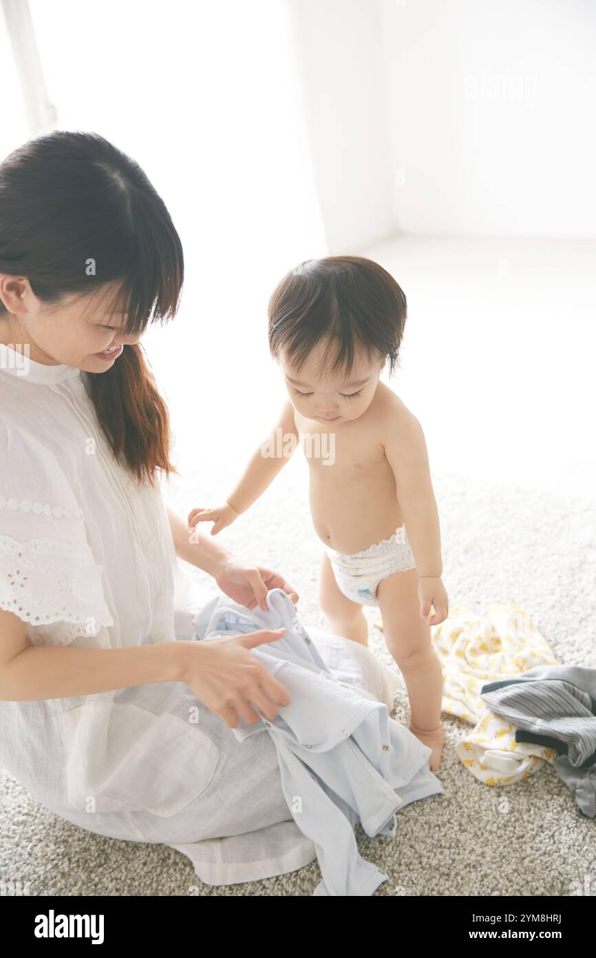 Baby getting dressed Stock Photo - Alamy