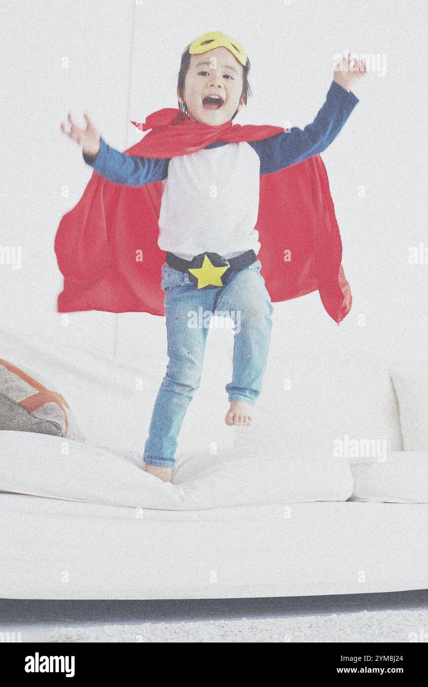 Little Superman jumping from the sofa Stock Photo - Alamy