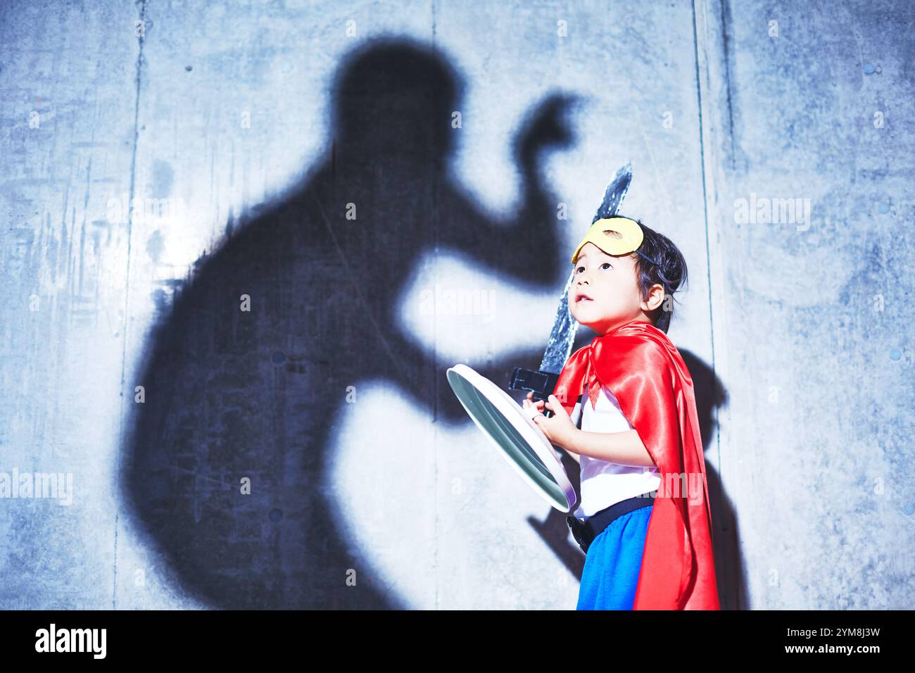 Little Superman fighting the bad guys Stock Photo - Alamy