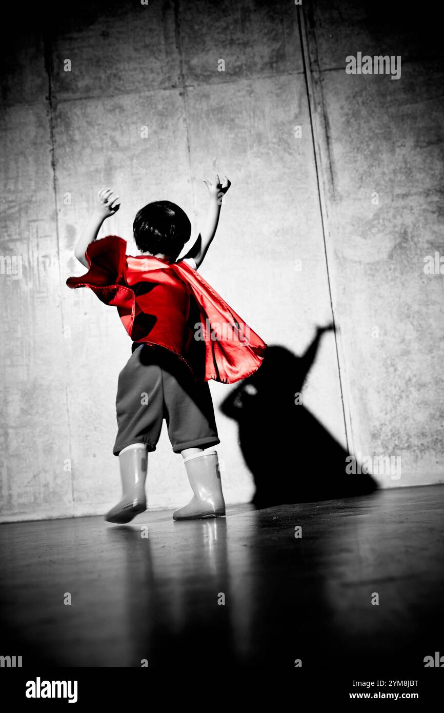 Hero boy posing in front of concrete wall Stock Photo - Alamy