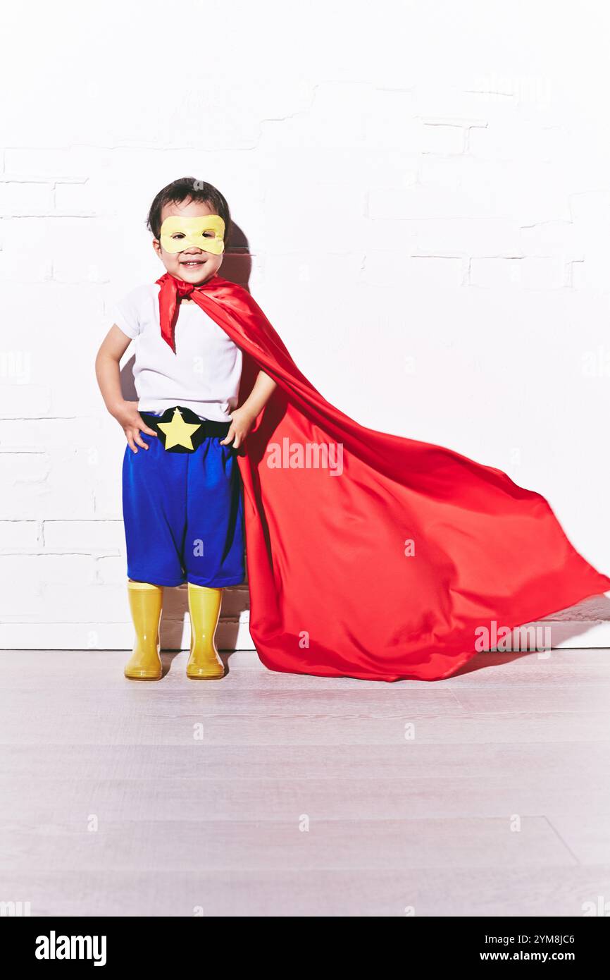 Hero boy doing victory pose in front of brick wall Stock Photo - Alamy