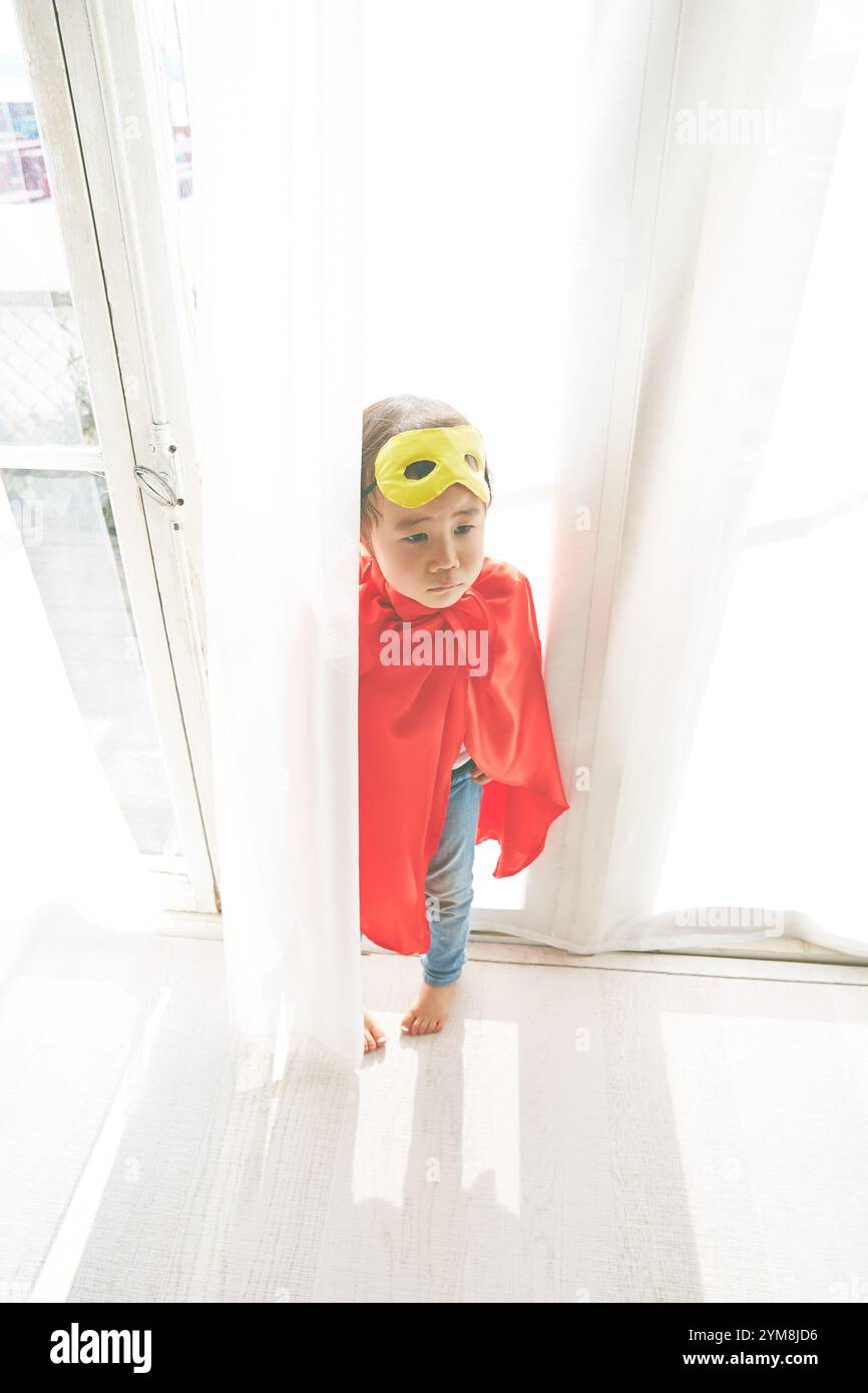Hero boy looking sad by the window Stock Photo - Alamy
