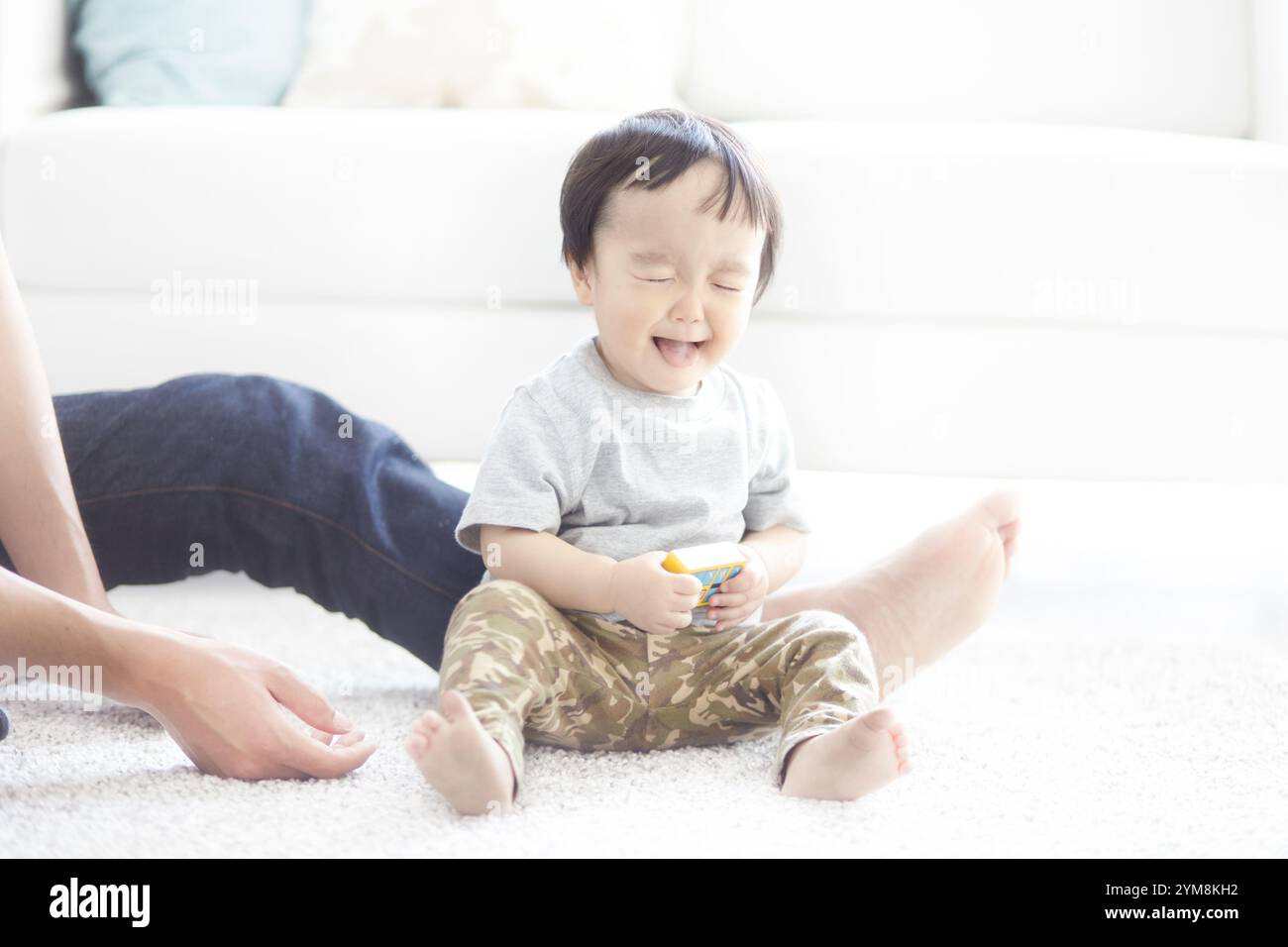Child playing with parents with an extraordinary smile Stock Photo - Alamy