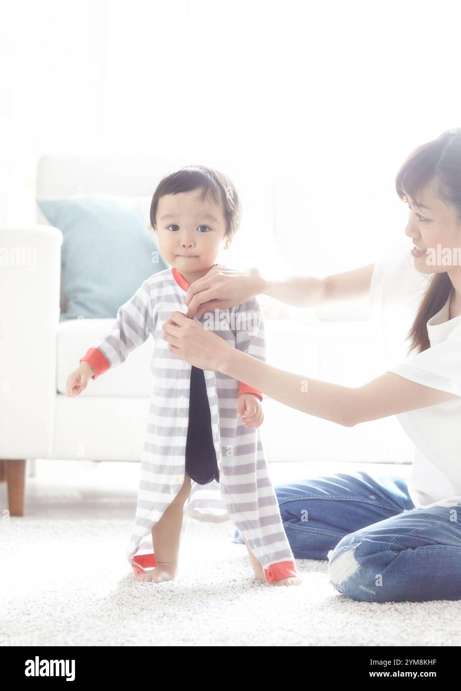 Child being dressed by her mother Stock Photo - Alamy