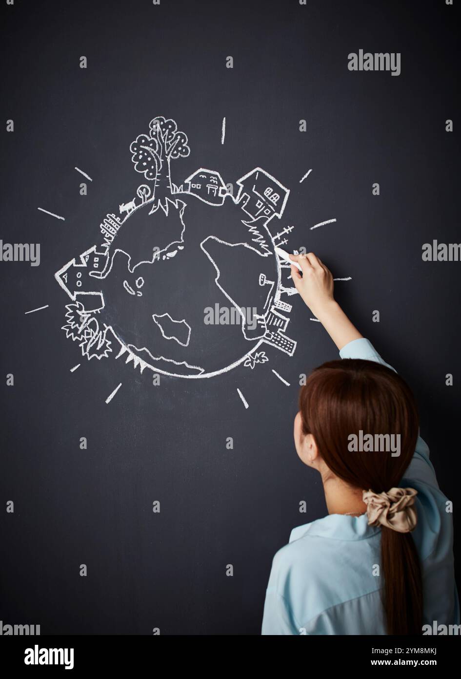 Woman drawing a picture of the earth on the blackboard Stock Photo - Alamy
