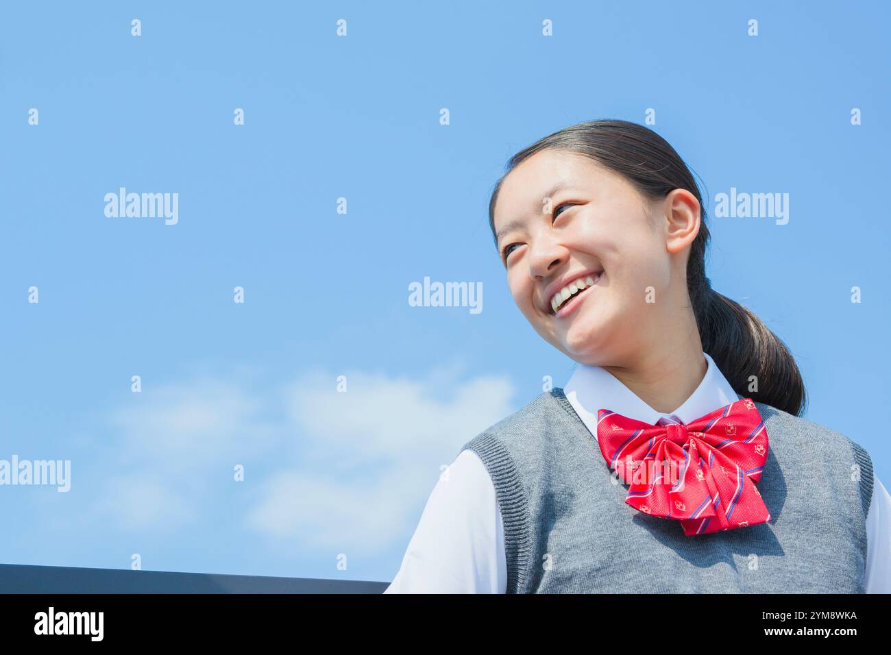 Blue sky and smiling female junior high school student Stock Photo - Alamy