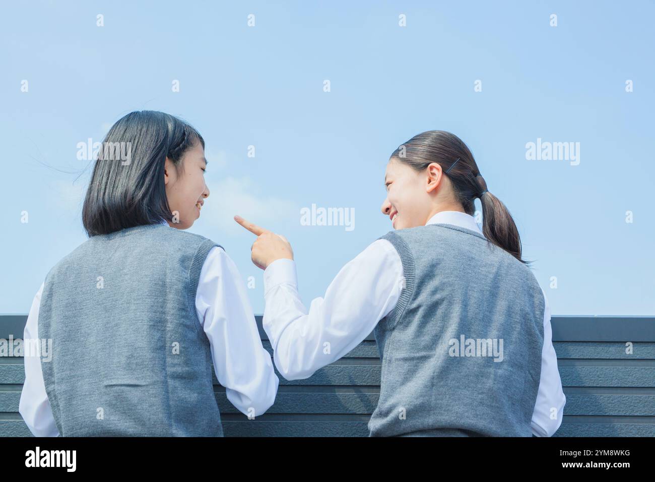 Blue sky and two female junior high school students, back view Stock ...