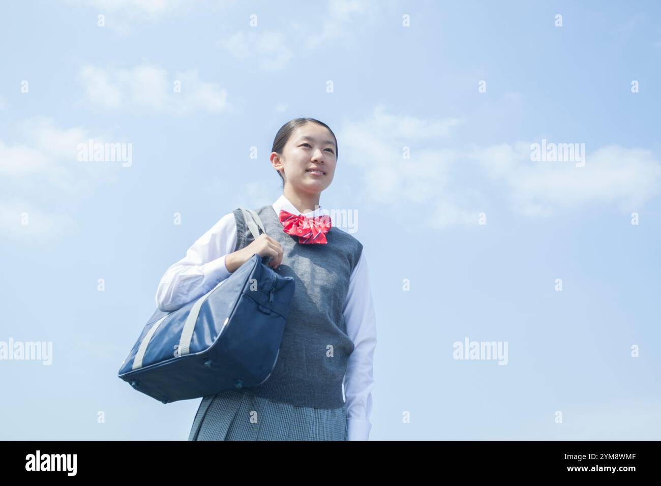 Blue sky and female junior high school student Stock Photo - Alamy