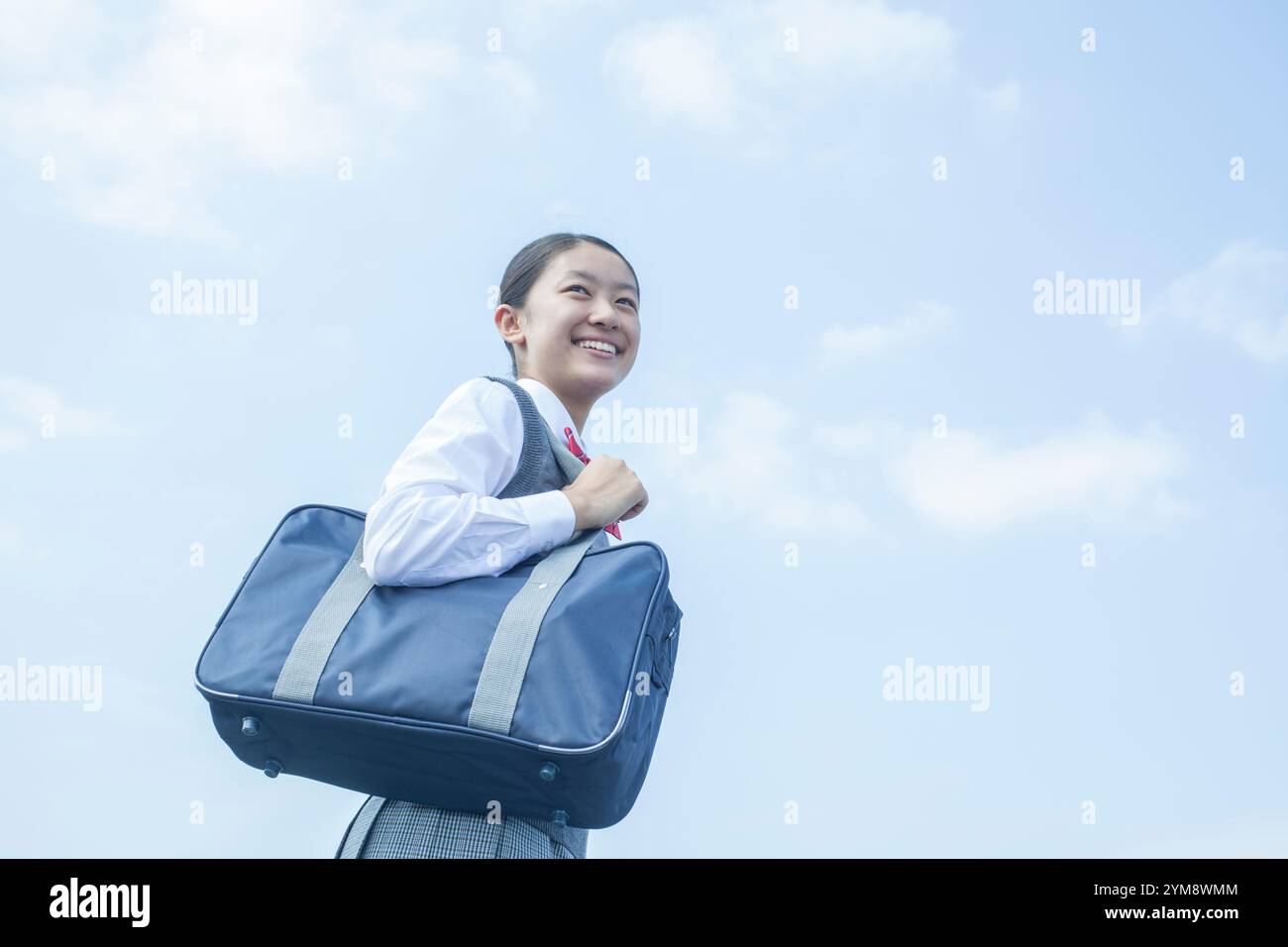 Blue sky and smiling female junior high school student Stock Photo - Alamy