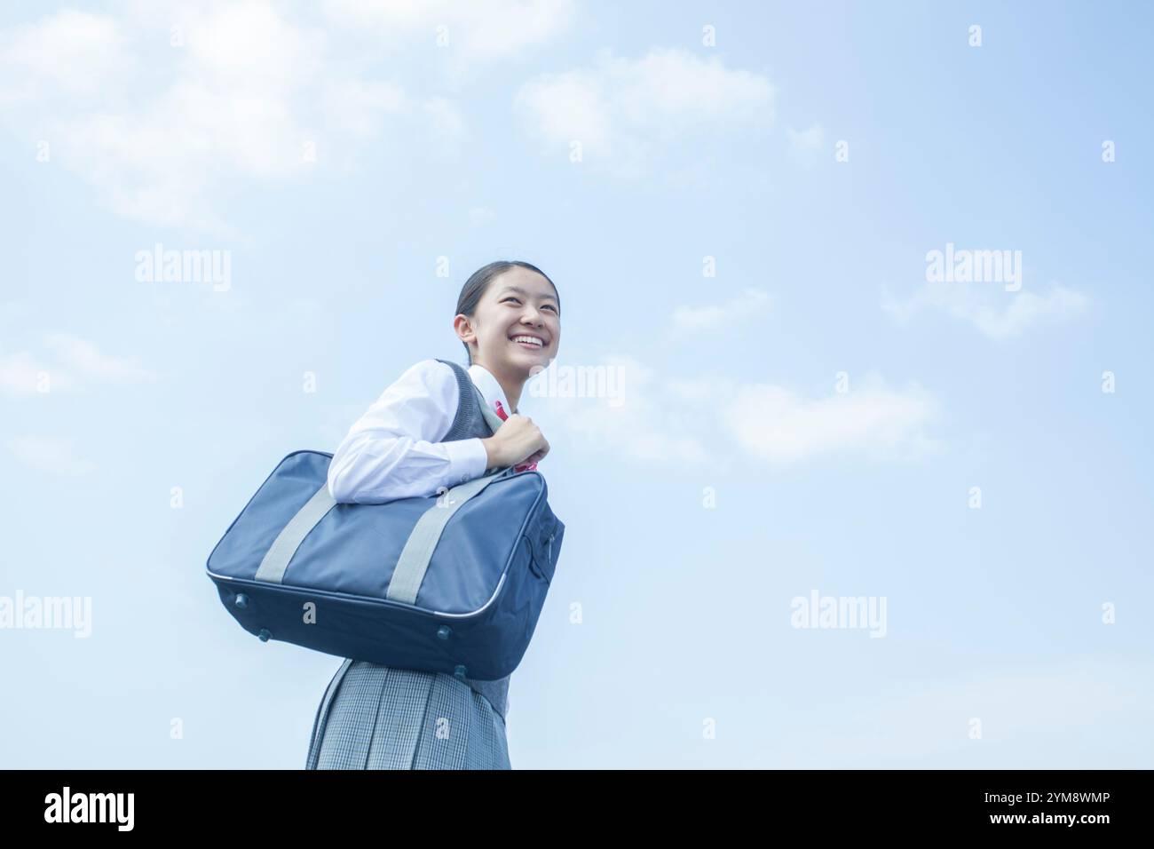 Blue sky and smiling female junior high school student Stock Photo - Alamy