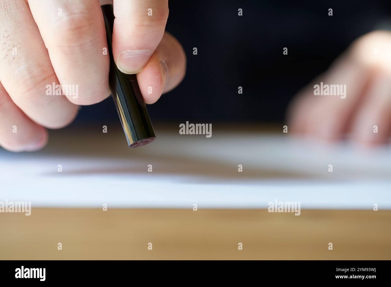 Hand of a man stamping on a document Stock Photo - Alamy