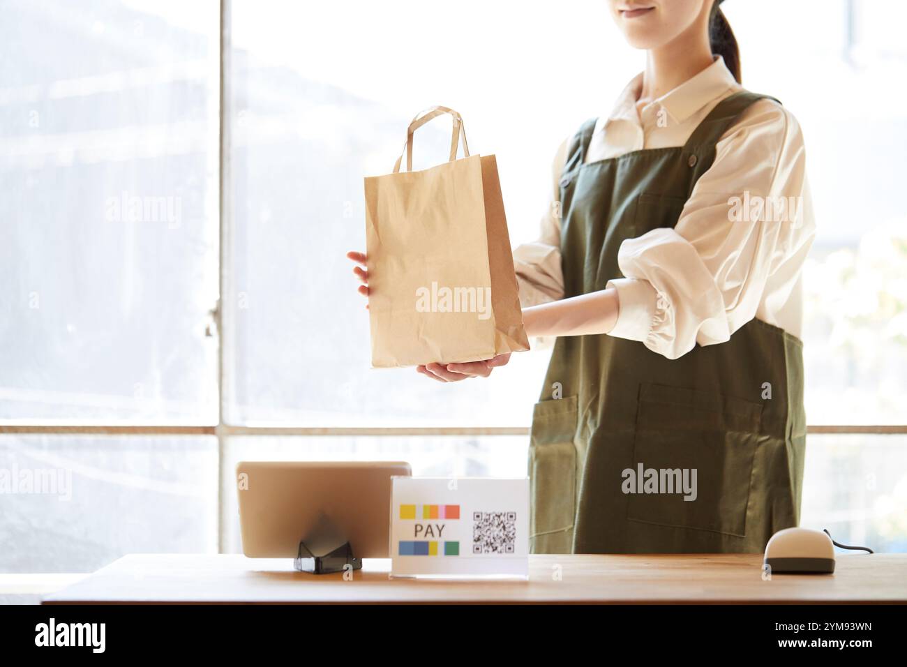 Female shopkeeper at cash register with cashless payment Stock Photo ...