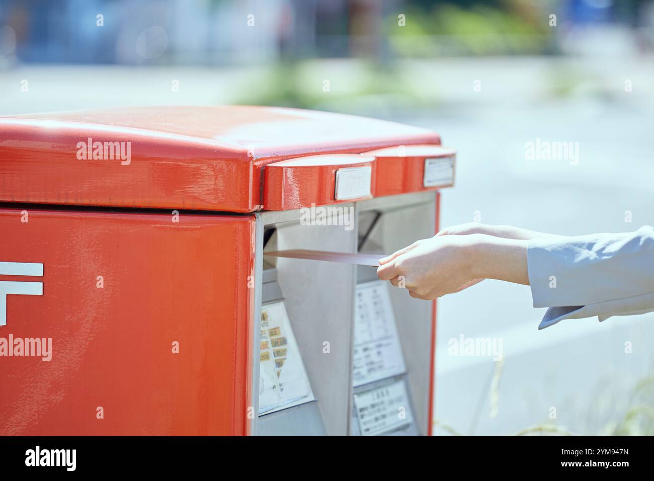 Young woman's hand putting an envelope in a mailbox Stock Photo - Alamy
