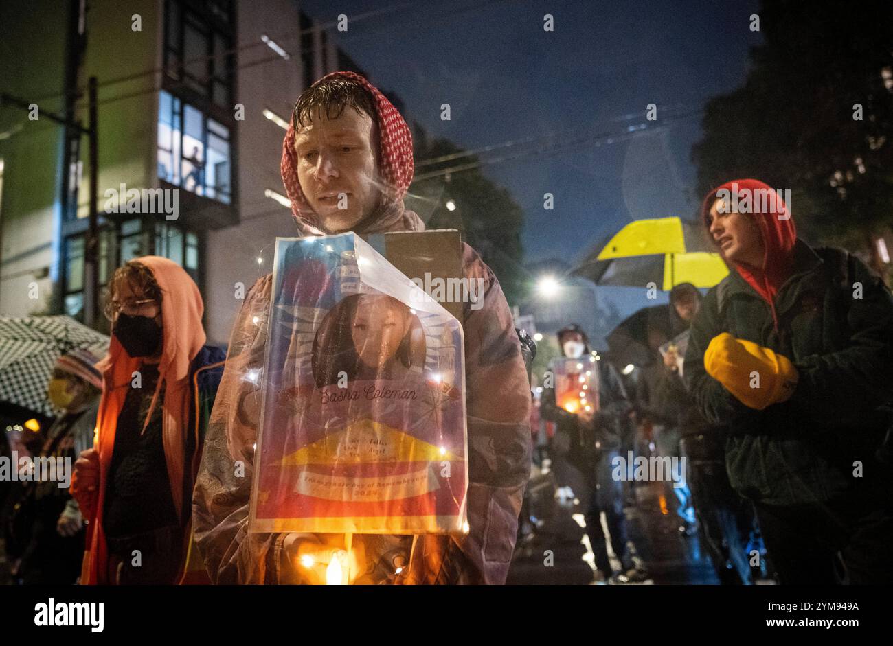 Matthew holds a poster of a trans individual who passed away during a ...