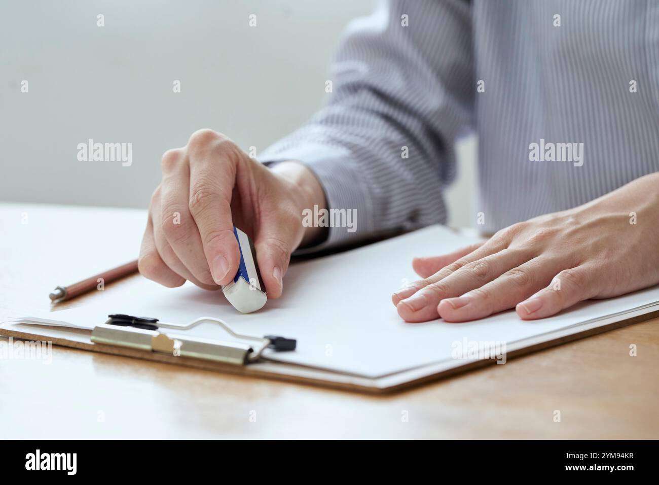 Woman erasing letters on a document with an eraser in her hand Stock ...