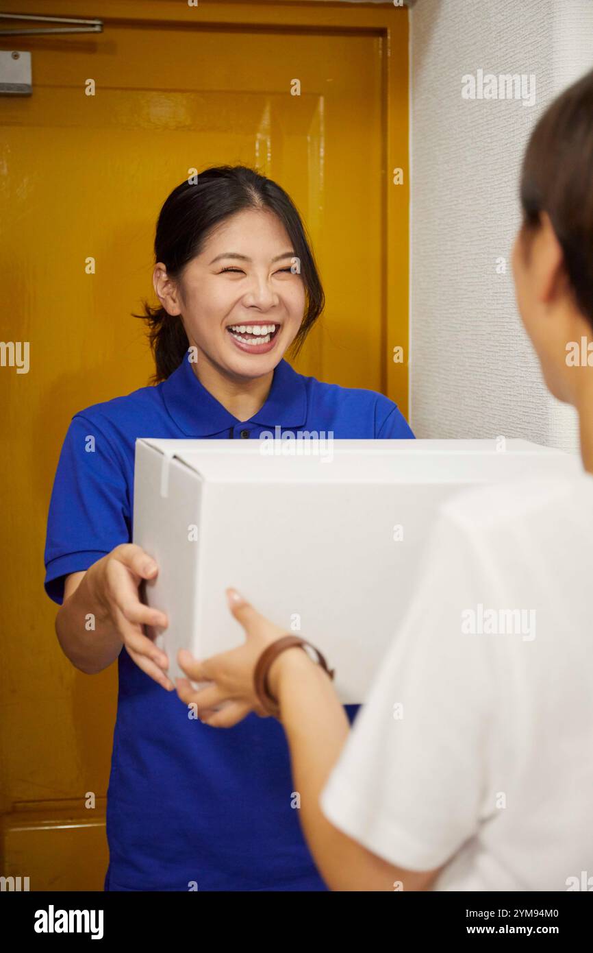 Young Japanese woman making a home delivery Stock Photo - Alamy