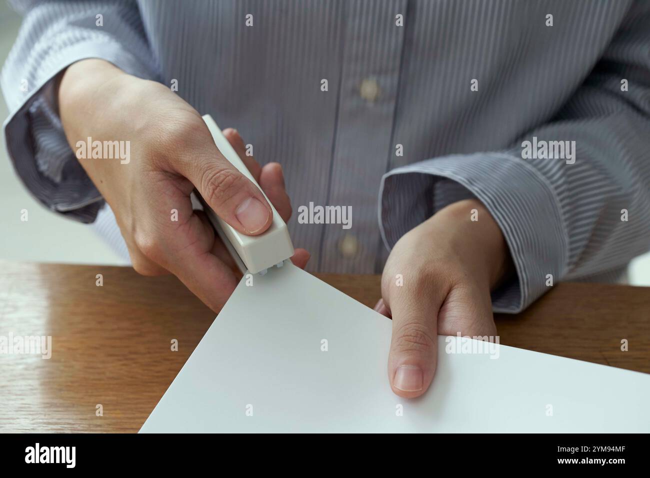 Woman's hand putting together documents with staples Stock Photo - Alamy