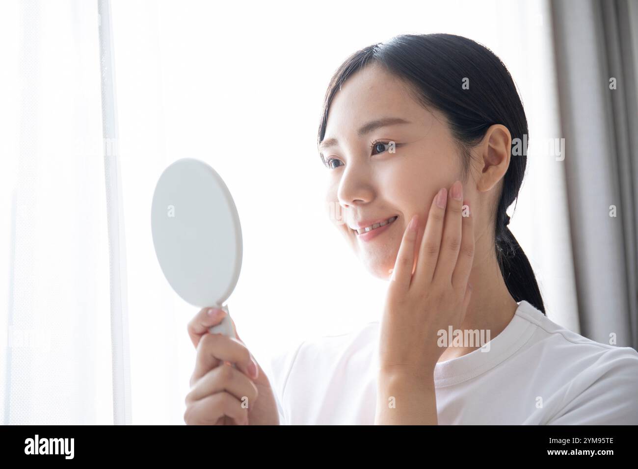 Young Japanese woman taking care of her skin in her room Stock Photo - Alamy