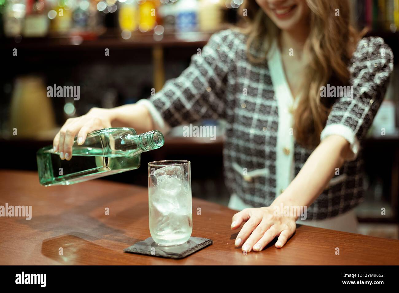 Young woman serving drinks at counter bar Stock Photo - Alamy