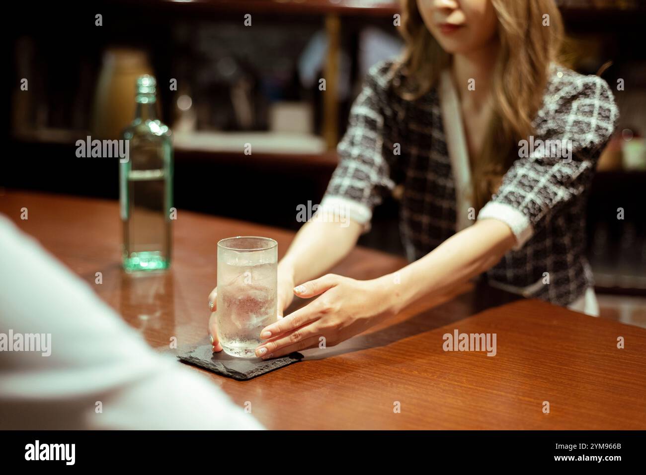 Young woman serving drinks at counter bar Stock Photo - Alamy