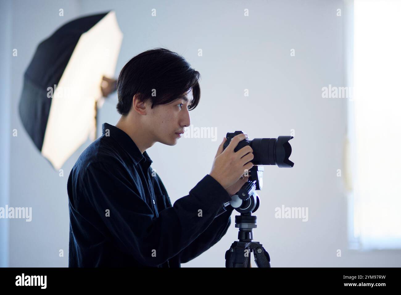 Japanese male photographer taking photographs at a photography studio ...