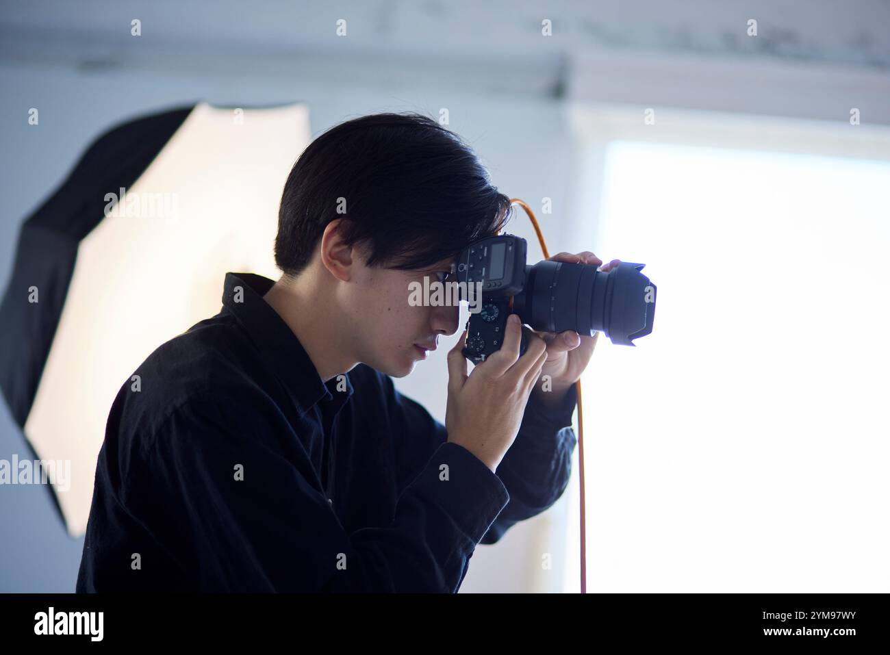 Japanese male photographer taking photographs at a photography studio ...