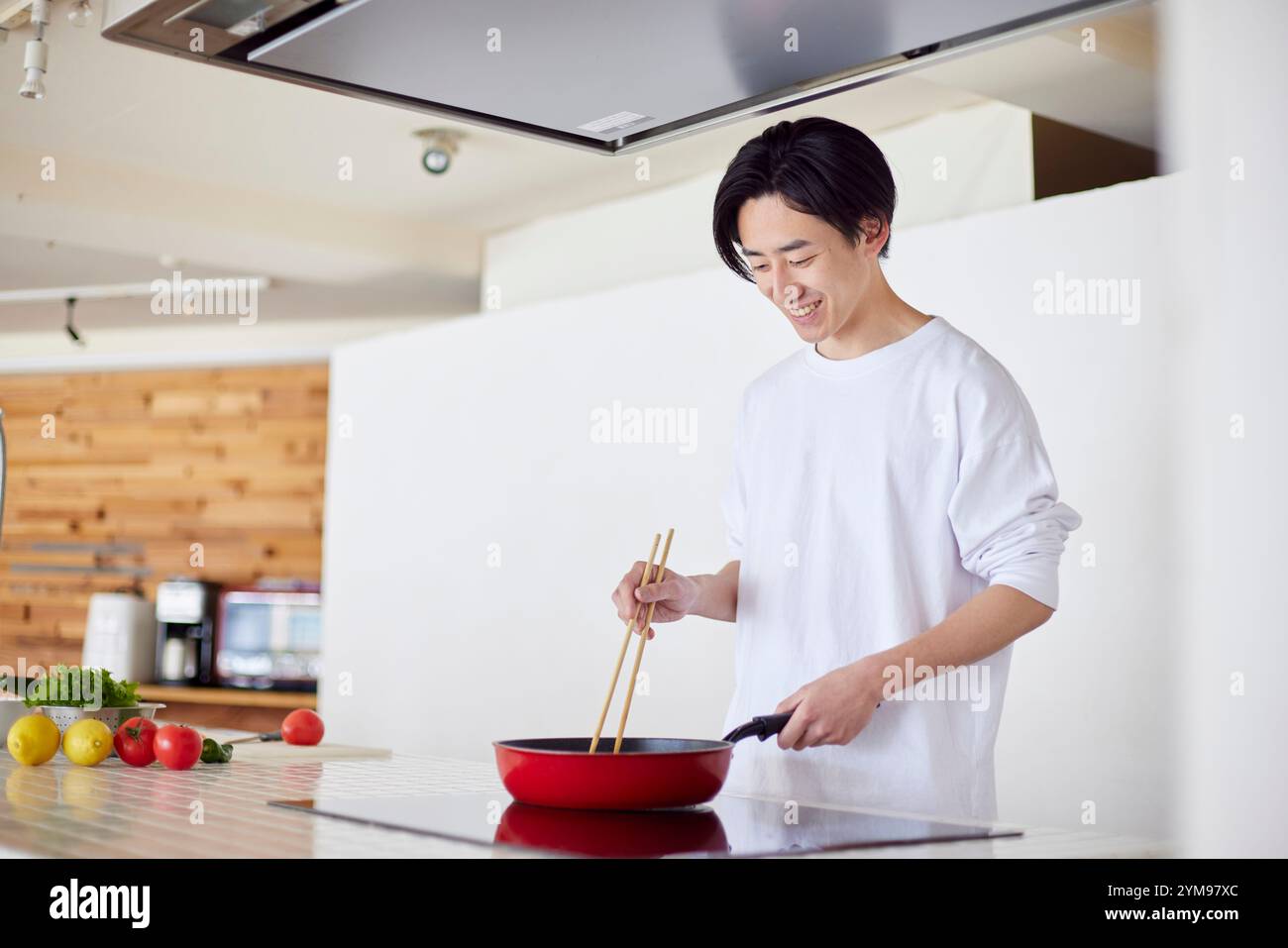 Young Japanese man cooking in the kitchen Stock Photo - Alamy