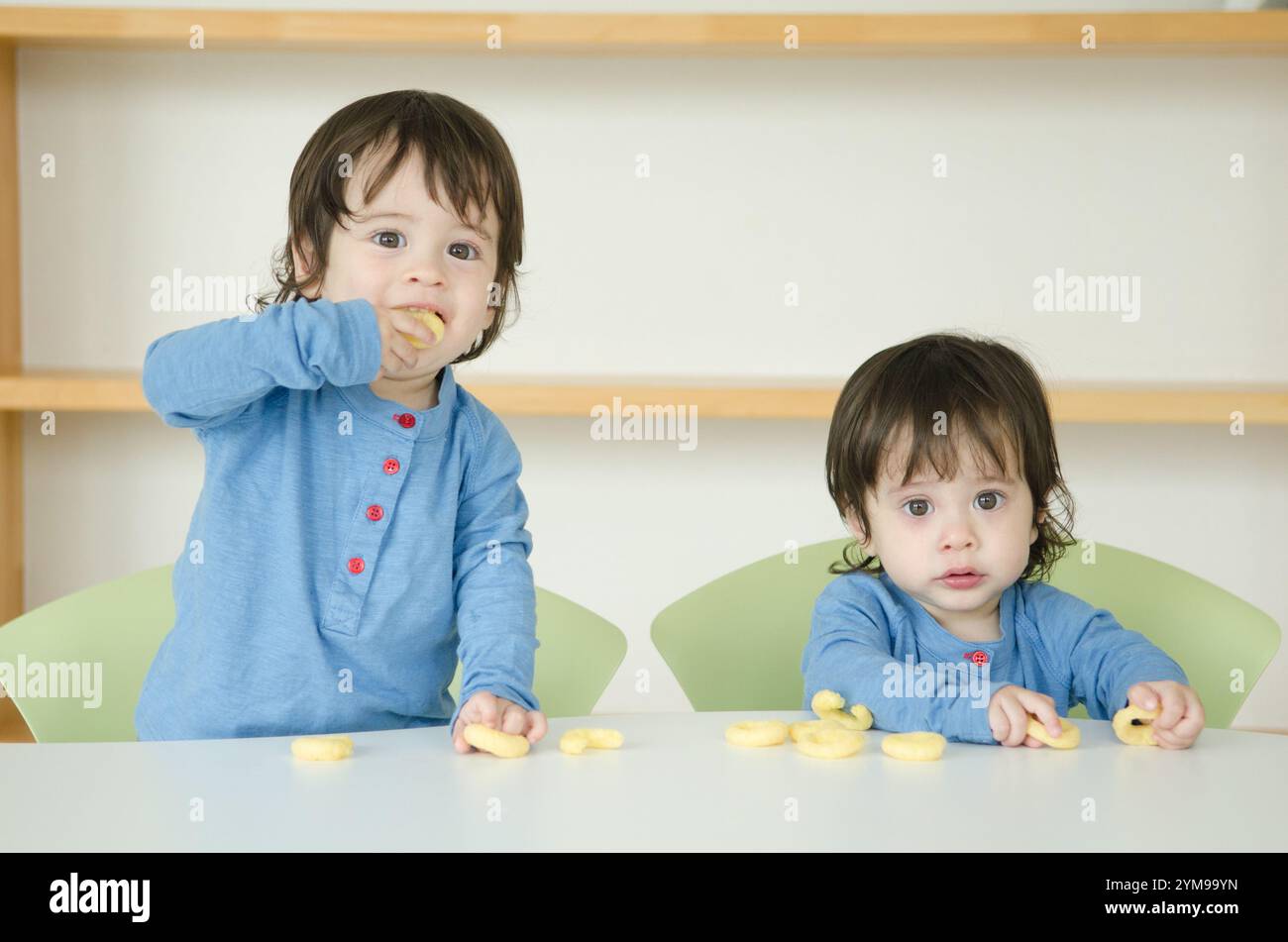 Twin boys eating a snack Stock Photo - Alamy