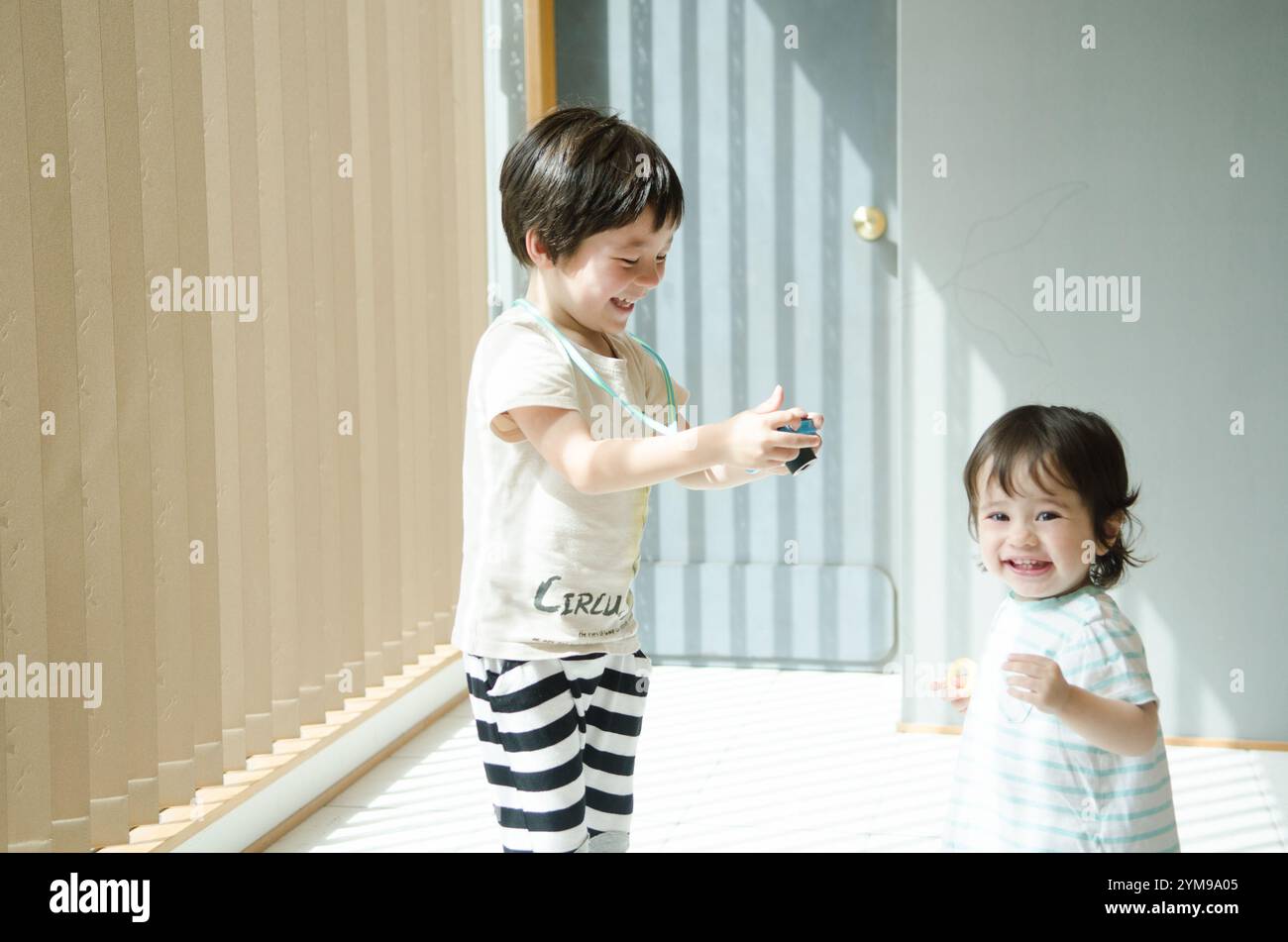 Child taking a picture of a small child with a camera Stock Photo - Alamy