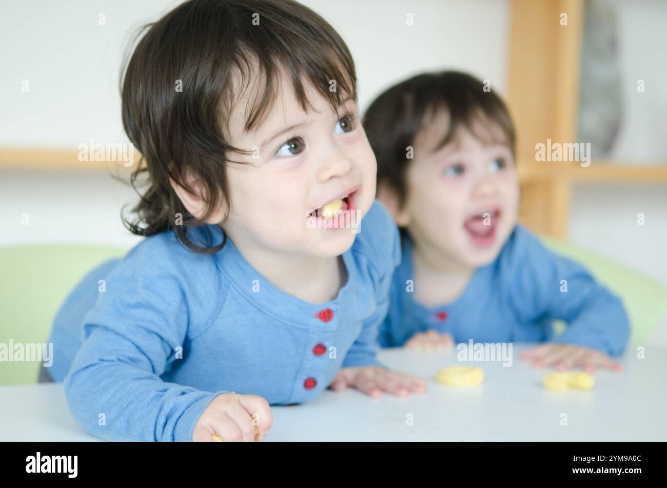 Twin boys eating a snack Stock Photo - Alamy