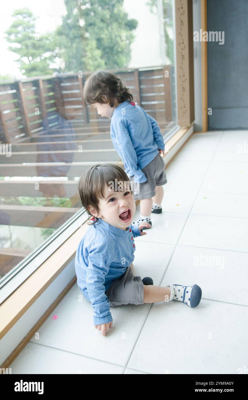 Twin boys playing inside a house Stock Photo - Alamy