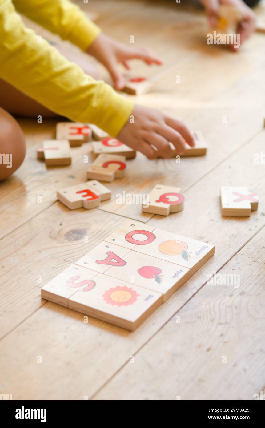 A child's hand playing with an English puzzle Stock Photo - Alamy