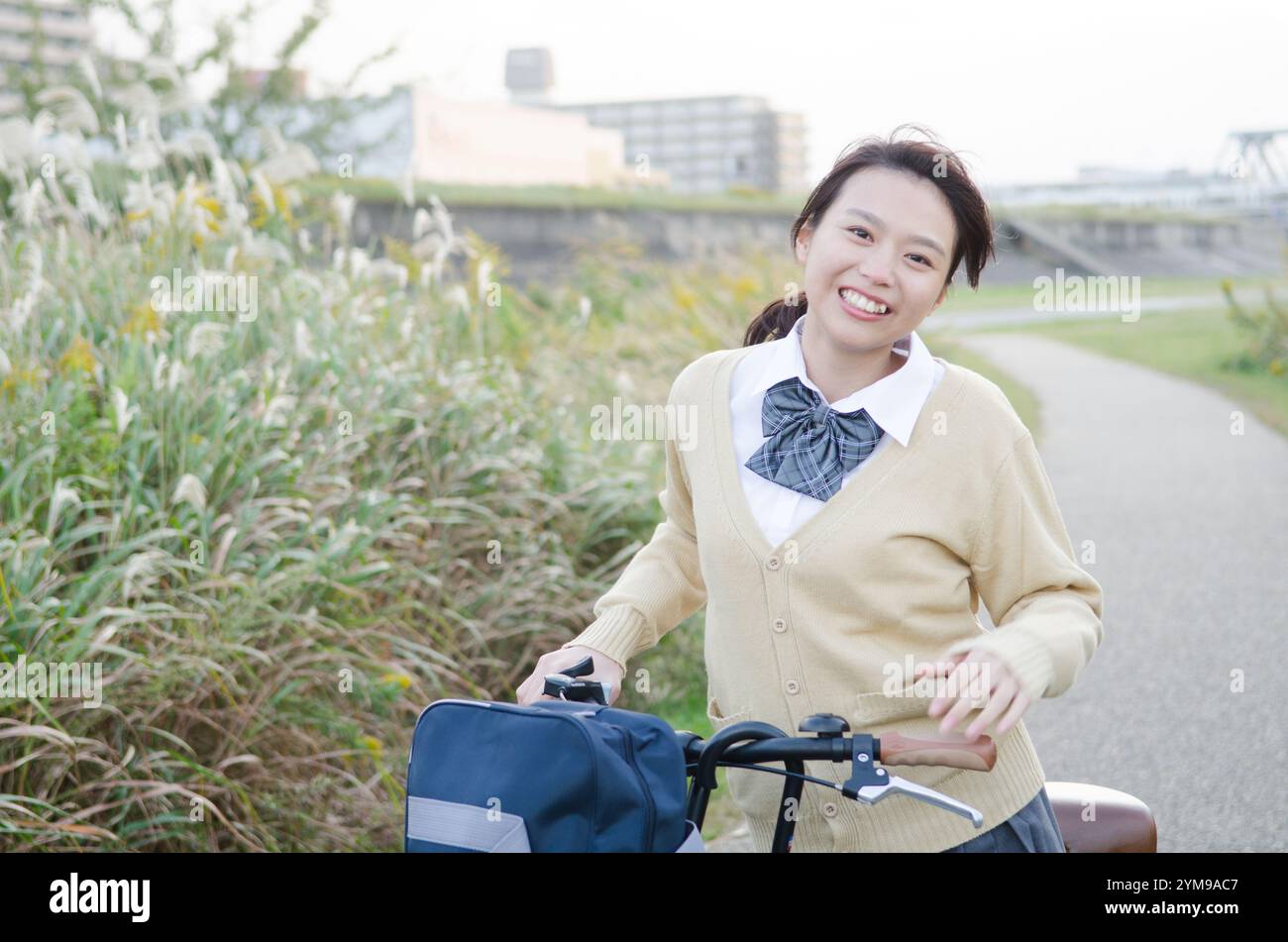 Female student pulling a bicycle Stock Photo - Alamy