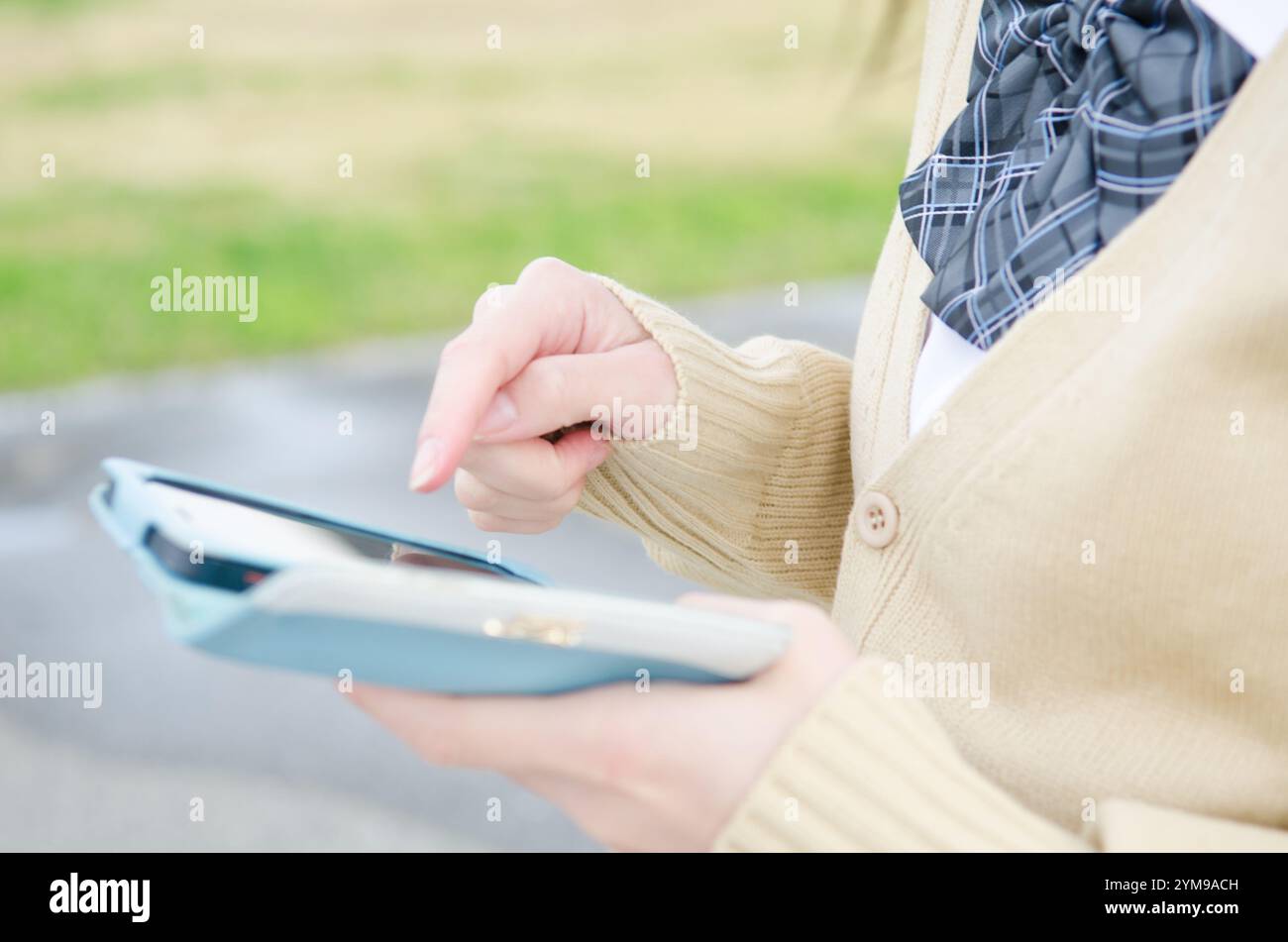 Female student's hand fiddling with her phone Stock Photo - Alamy