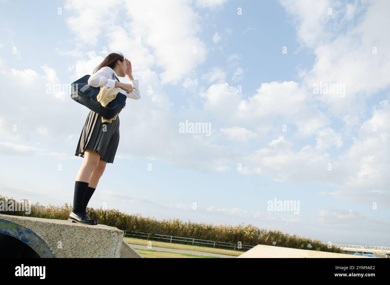Female student standing and looking into the distance Stock Photo - Alamy