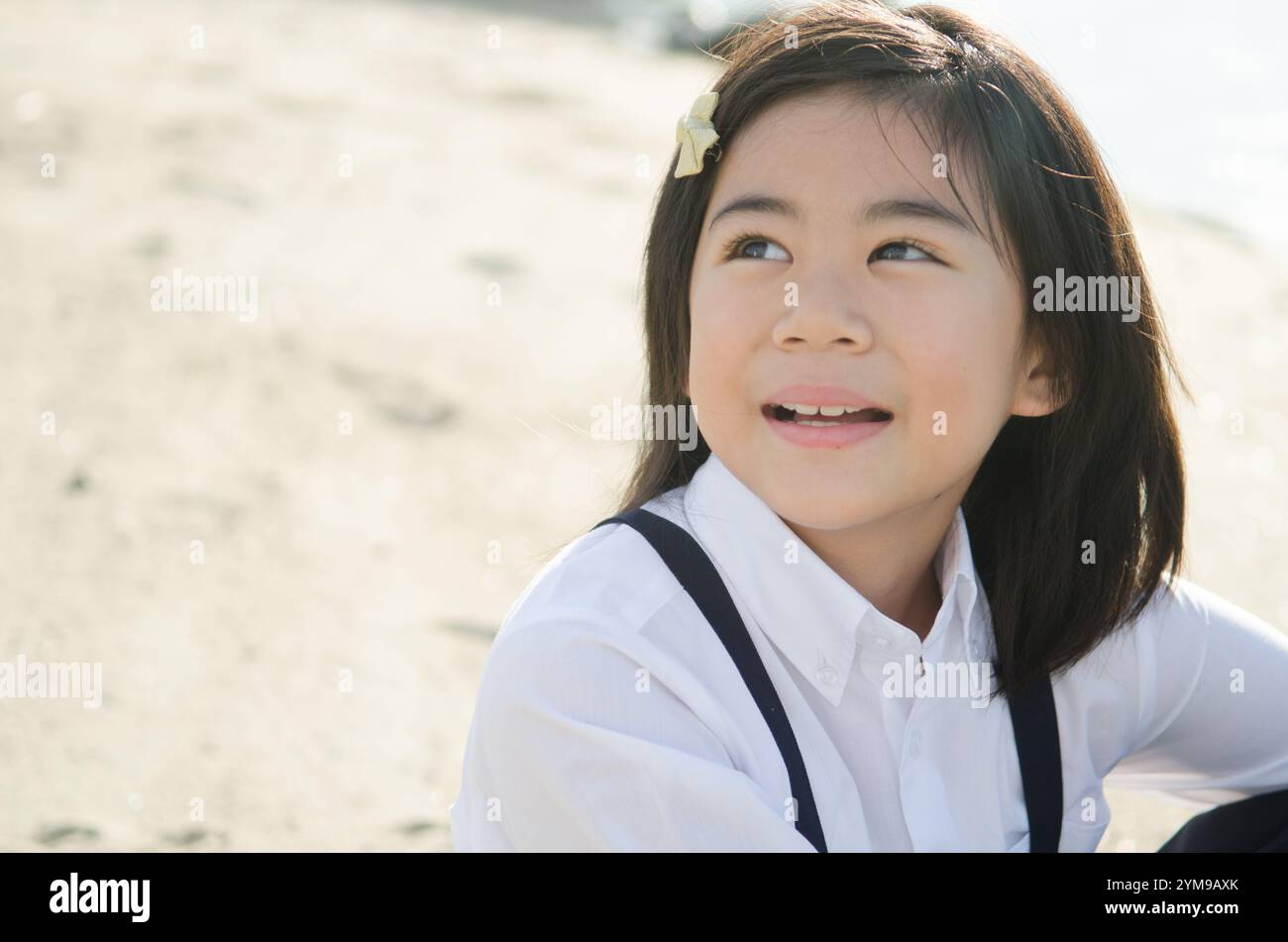 Primary school girl turning around and smiling Stock Photo - Alamy