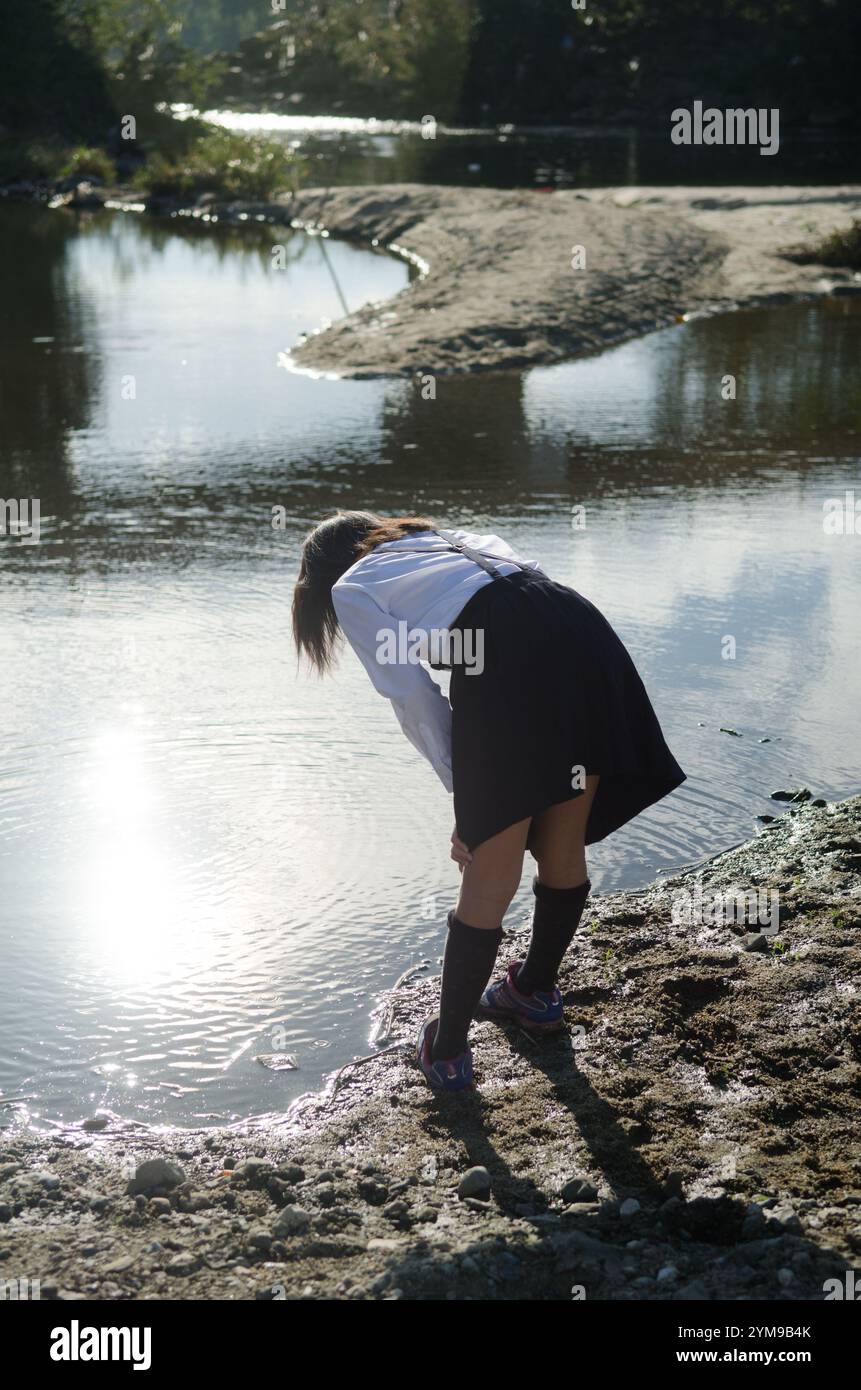 Primary schools girl playing by the water, looking back Stock Photo - Alamy