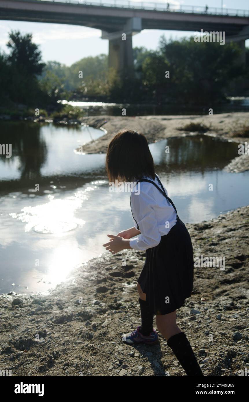 Primary schools girl playing by the water, looking back Stock Photo - Alamy