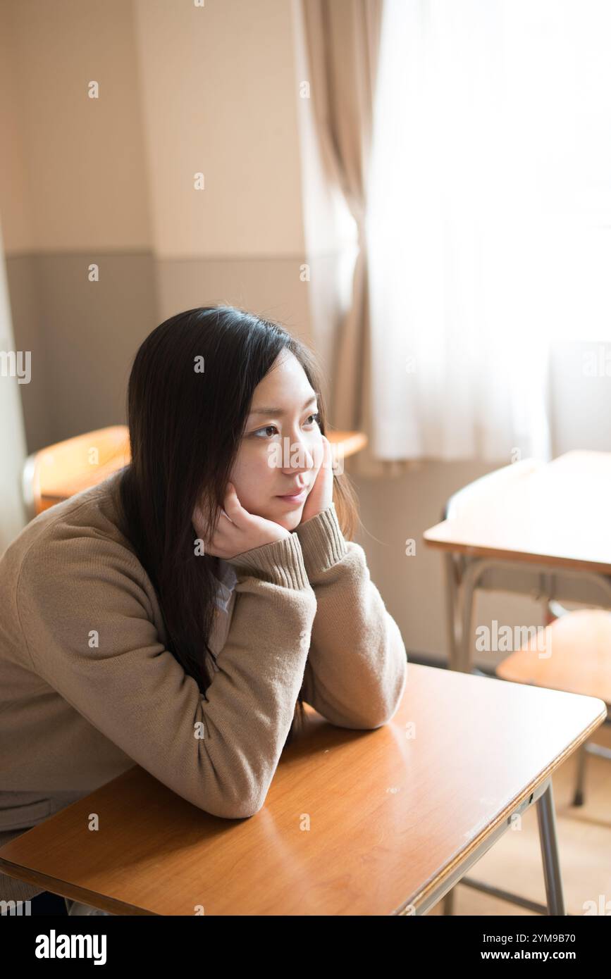High school girl with cheekbones at a desk Stock Photo - Alamy