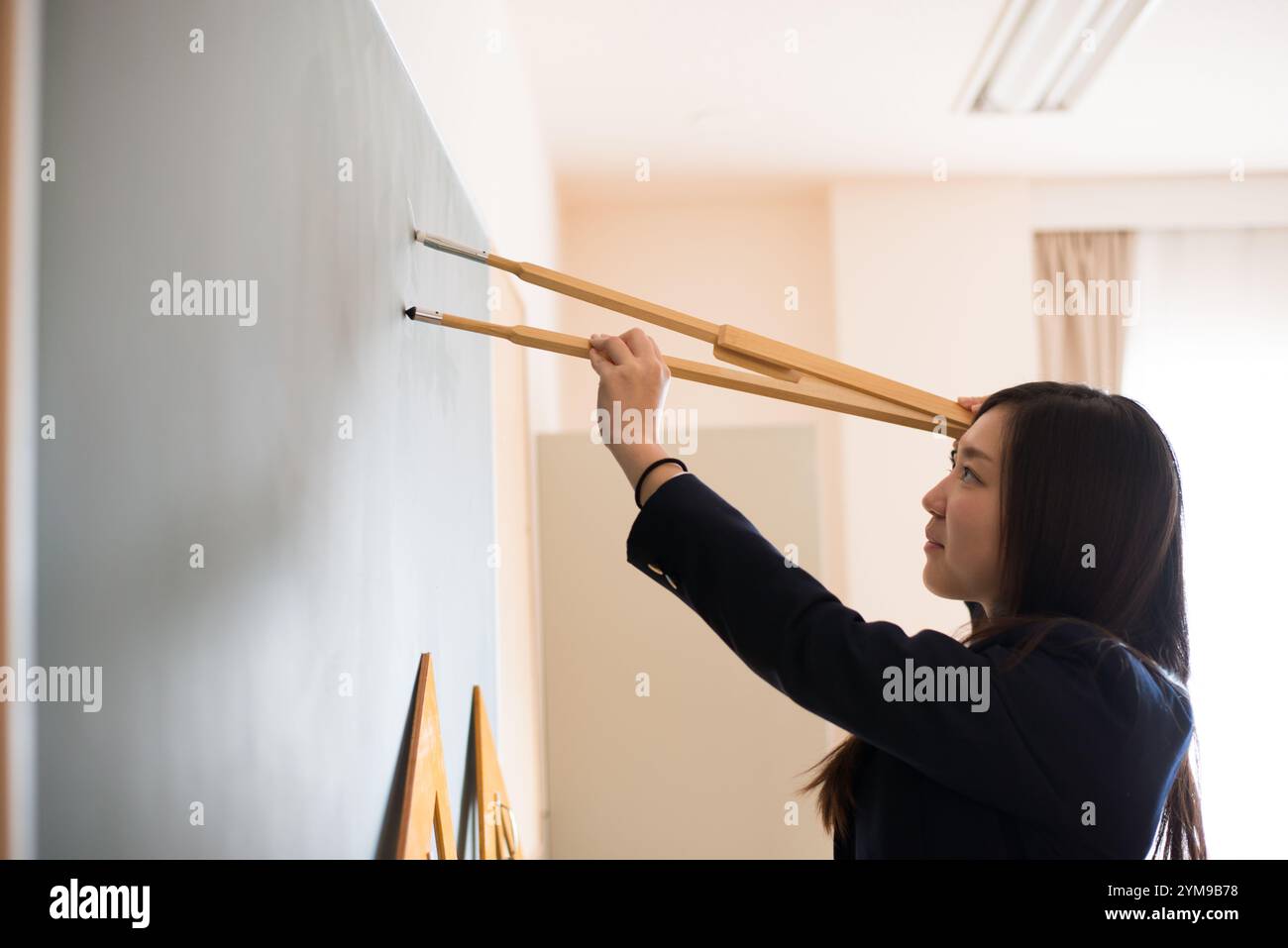Female high school student using a compass on the blackboard Stock ...