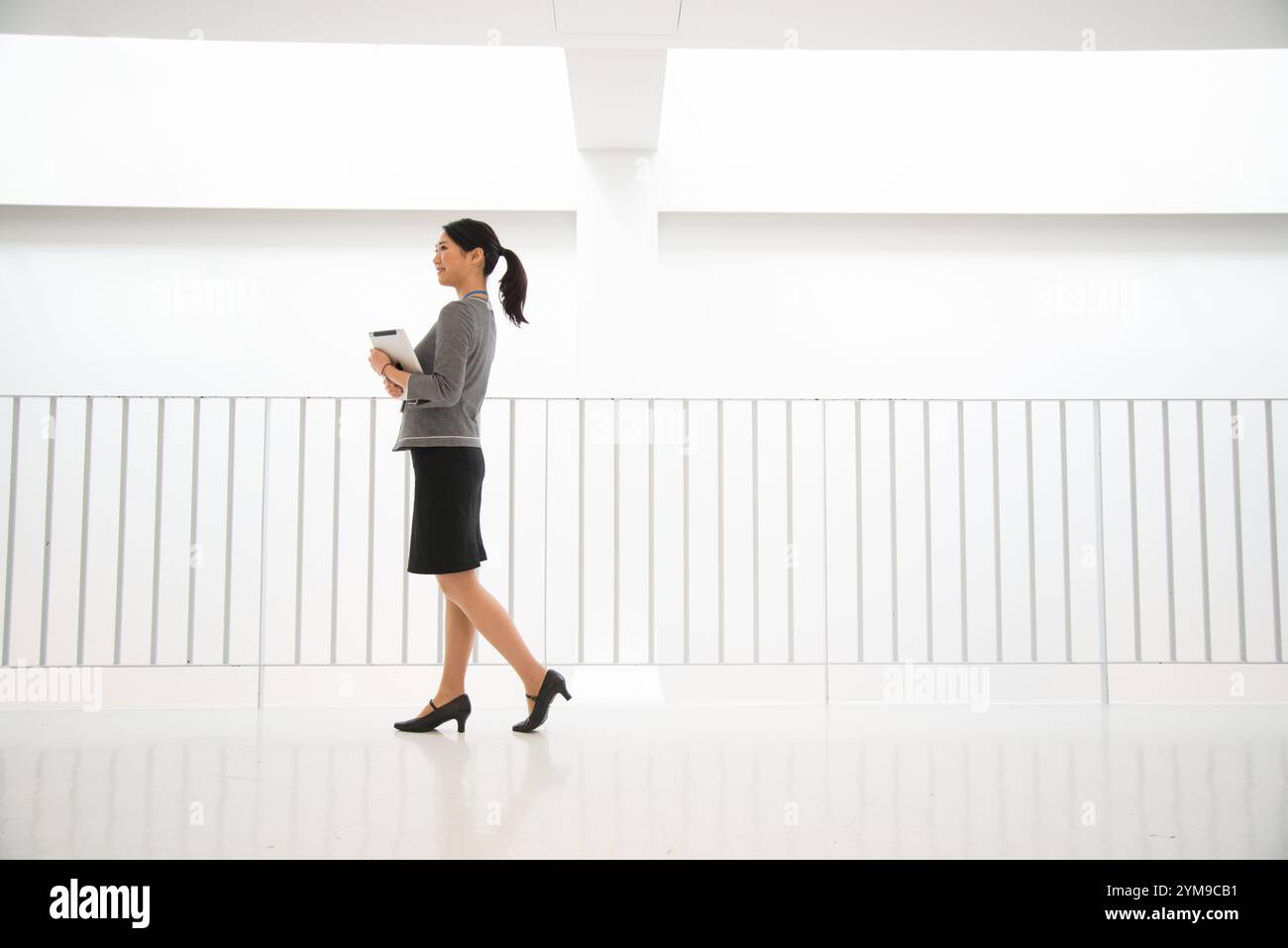 Woman walking holding tablet Stock Photo - Alamy