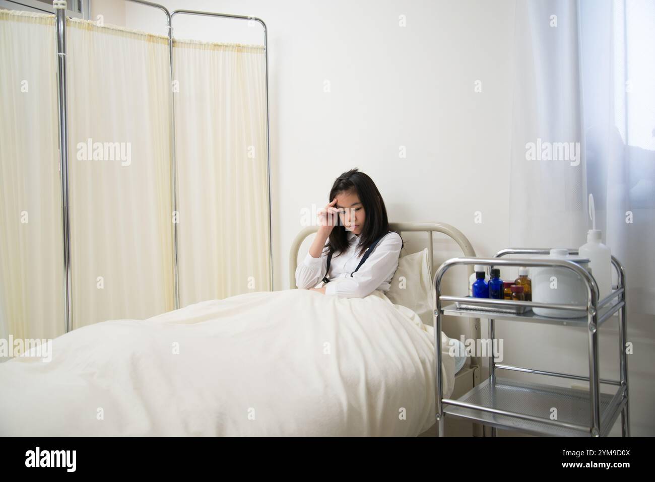 Primary school girl in bed in the infirmary, looking unwell Stock Photo ...