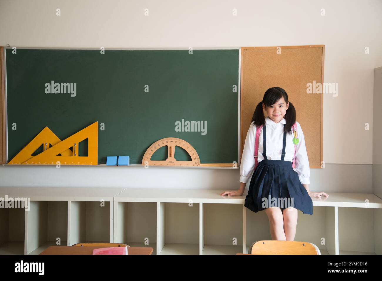 Primary school girl sitting at the back of the classroom Stock Photo ...