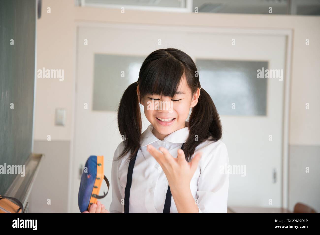 Primary schools girl holding blackboard eraser Stock Photo - Alamy