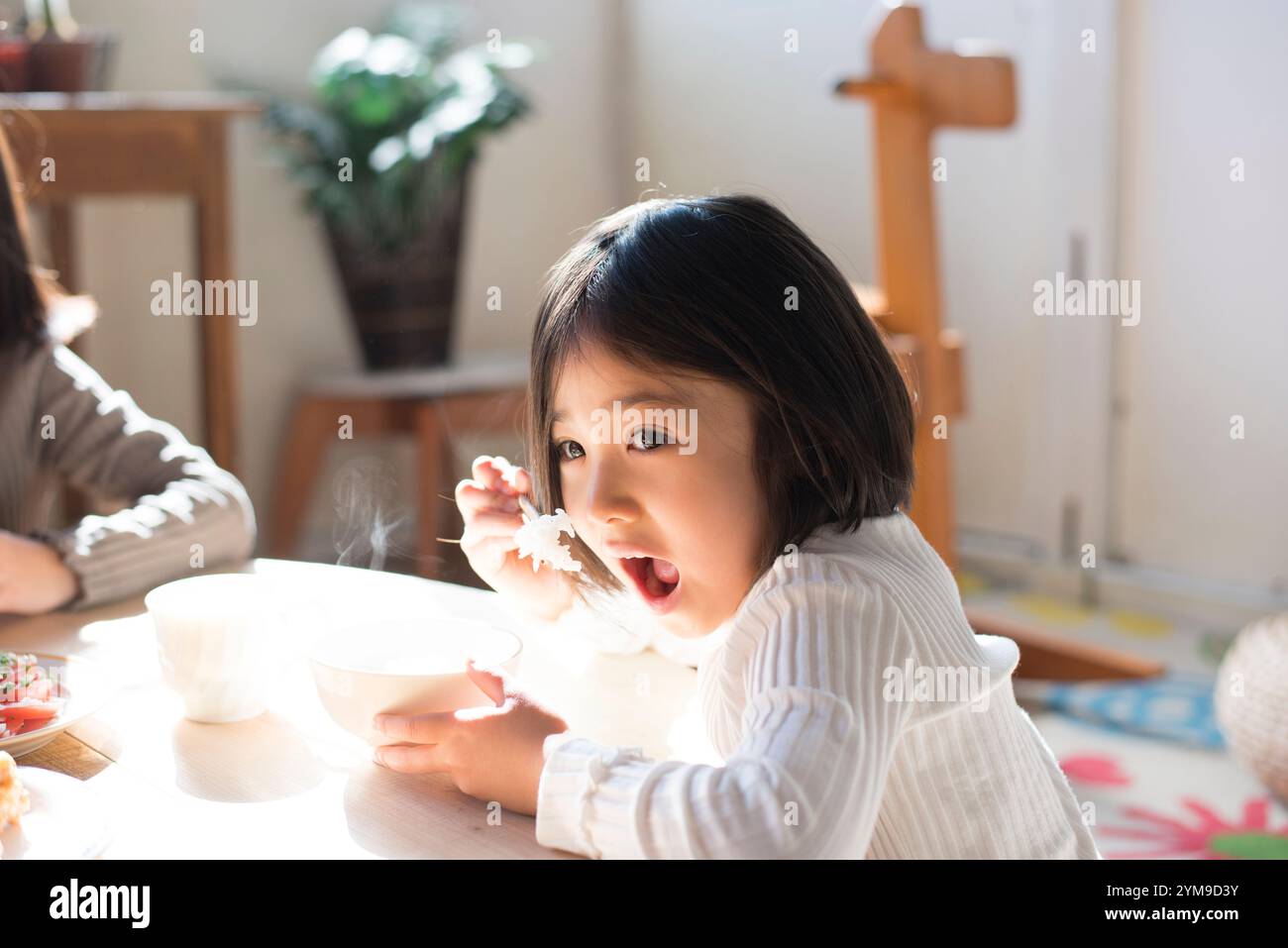 Girl eating rice Stock Photo - Alamy